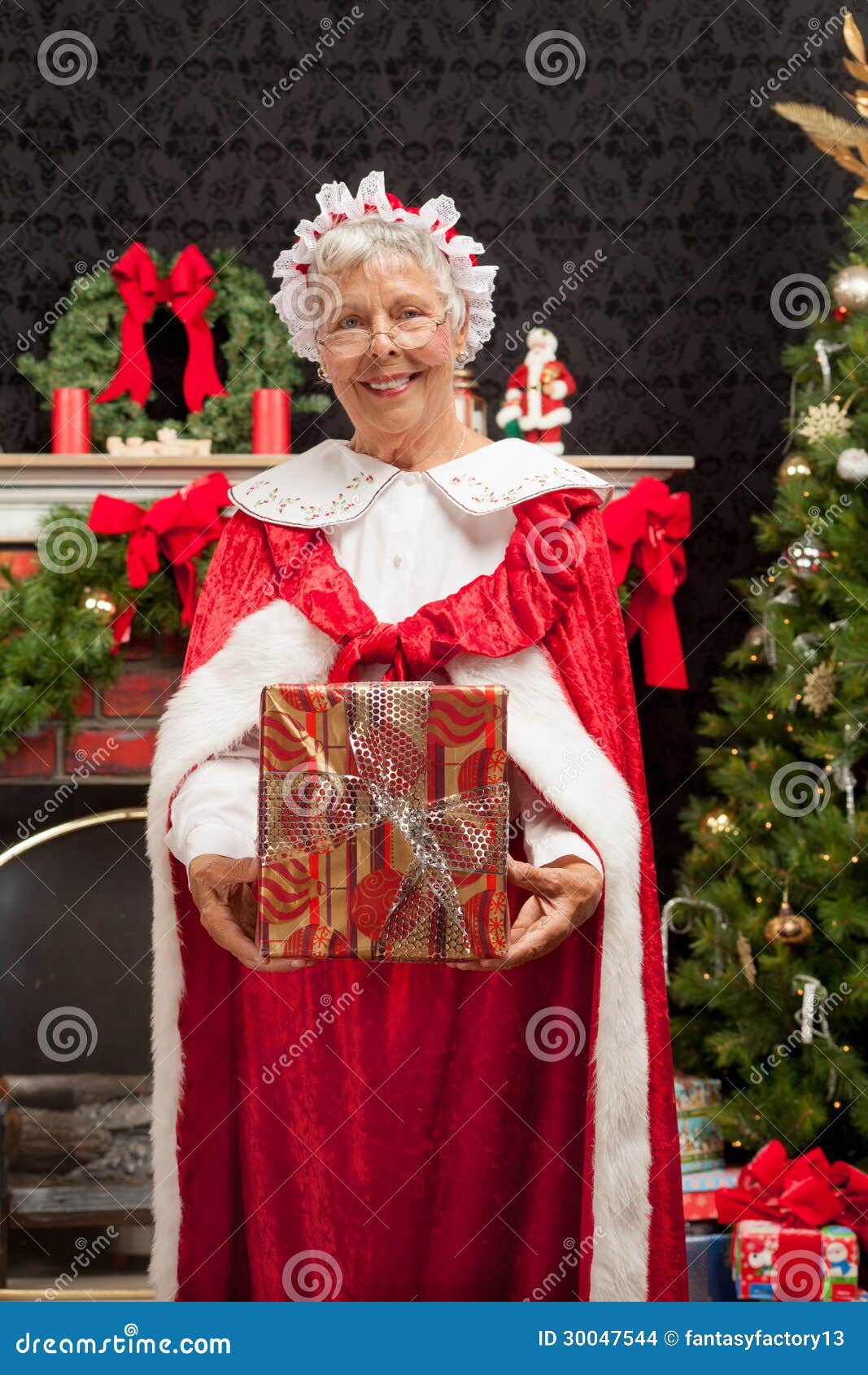 Mrs. Clause Holding a Christmas Present Stock Photo - Image of clause ...