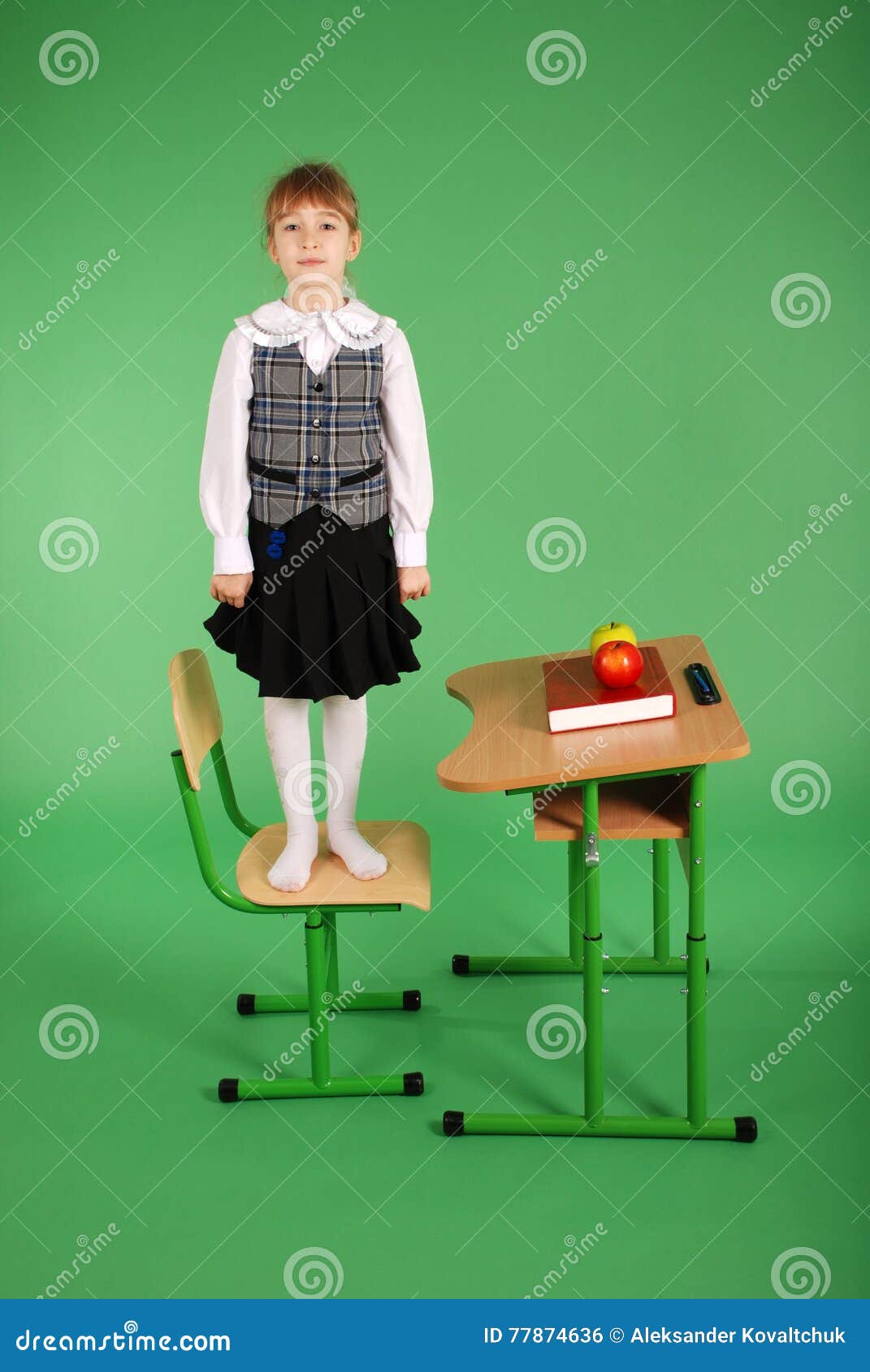 Muchacha En El Uniforme Escolar Que Se Coloca En Una Silla Foto De Archivo Imagen De Manzana