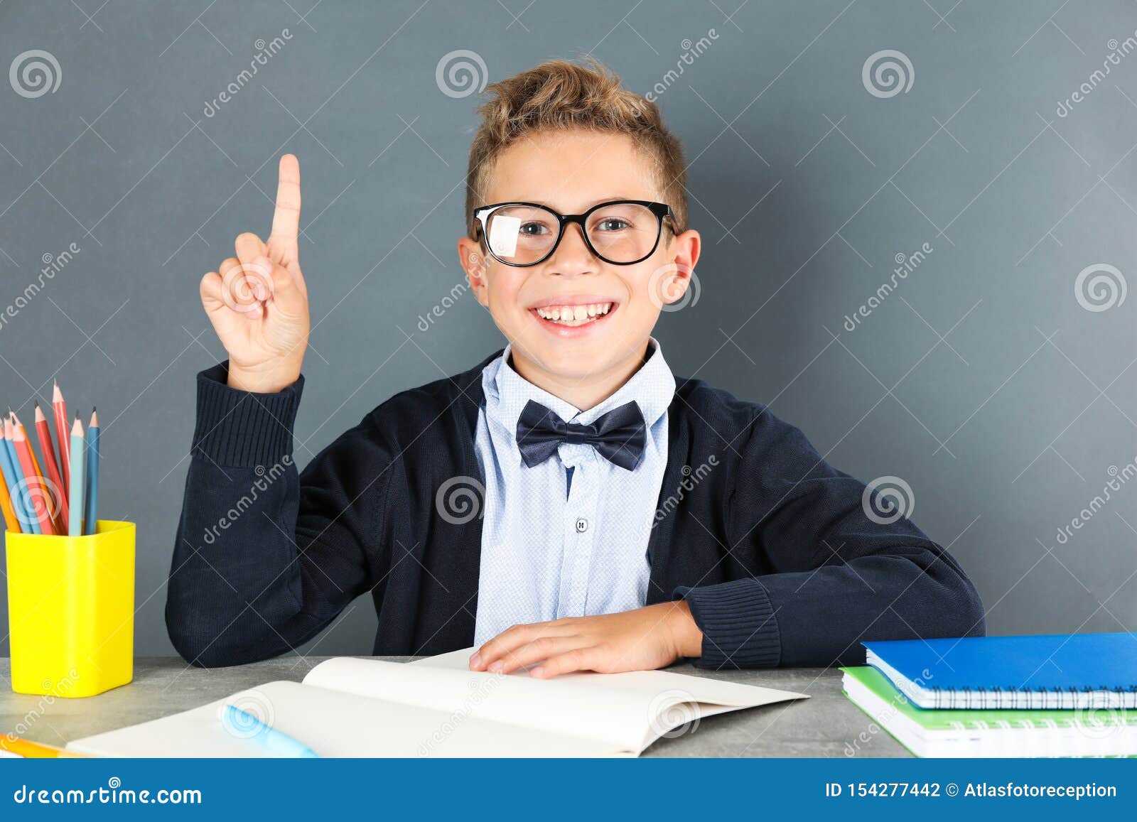Muchacho En El Uniforme Escolar Que Se Sienta En La Tabla Foto De Archivo Imagen De Poco