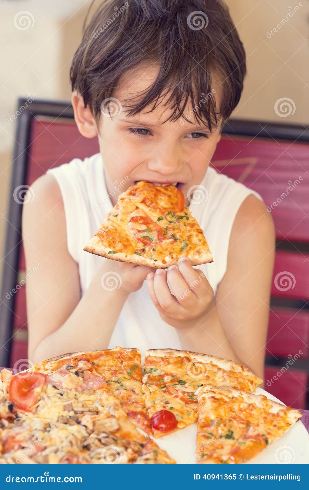 Muchacho que come la pizza imagen de archivo. Imagen de complazca ...