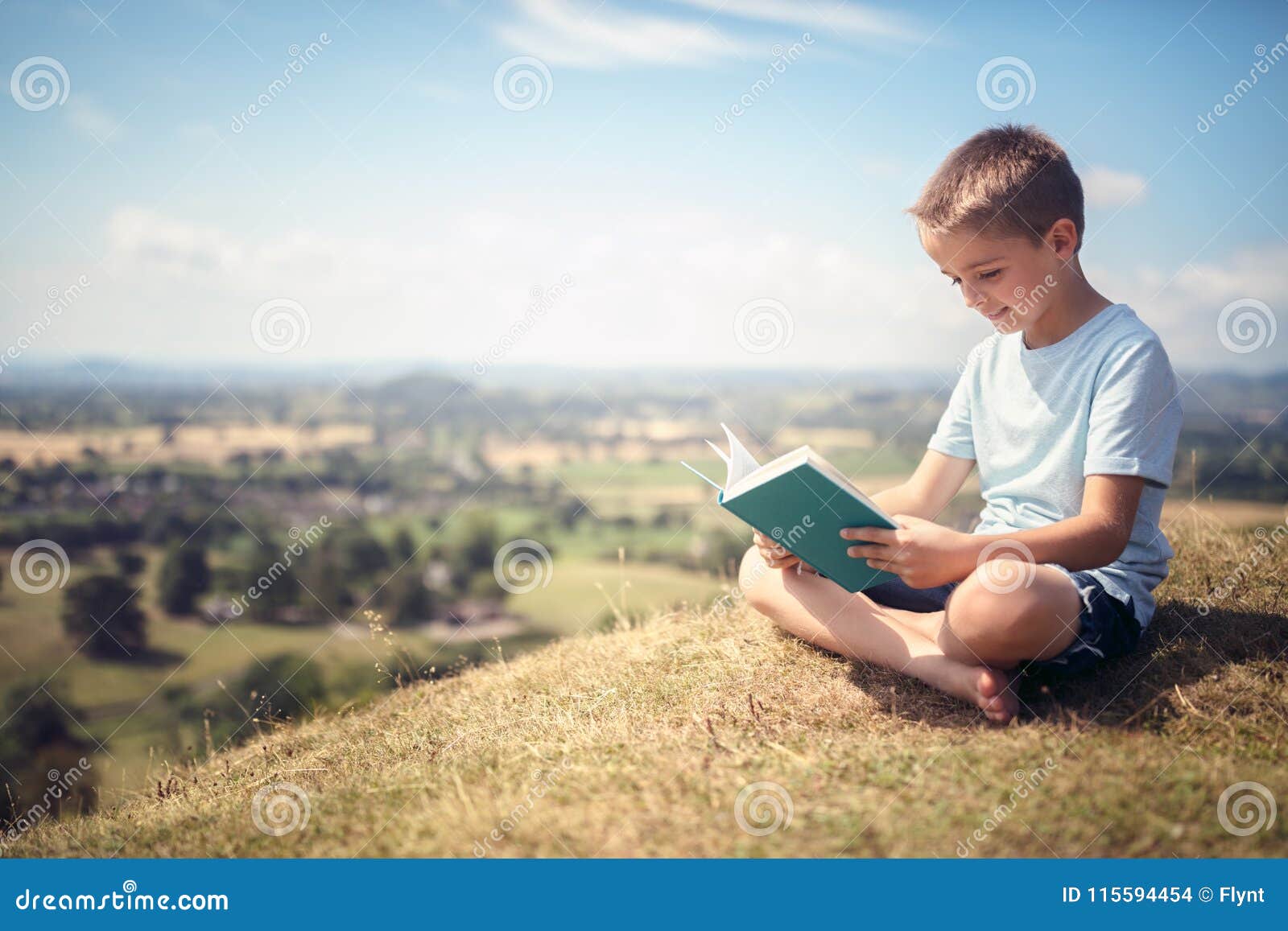 Muchacho Que Se Sienta En Una Colina Que Lee Un Libro En Un Prado Foto ... Muchacho Que Se Sienta En Una Colina Que Lee Un Libro En Un Prado Foto ...