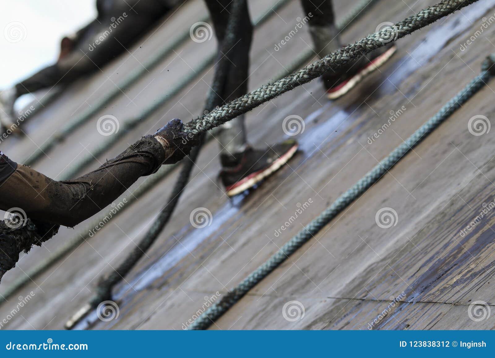 Mud Race Runners,defeating Obstacles by Using Rope Stock Photo - Image ...
