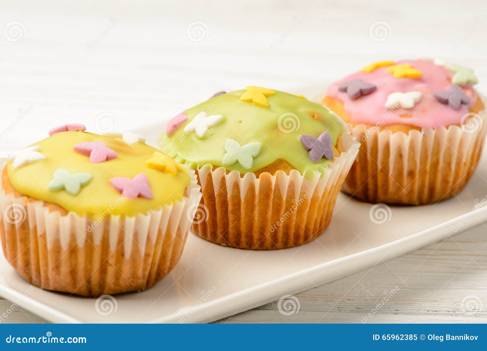 Muffins Covered with Colorful Icing Sugar on the Wooden Board. Stock ...