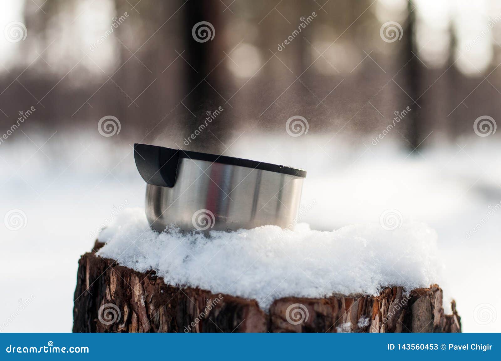 A Mug of Hot Tea Stands on a Snow-covered Stump in the Winter, Cold ...