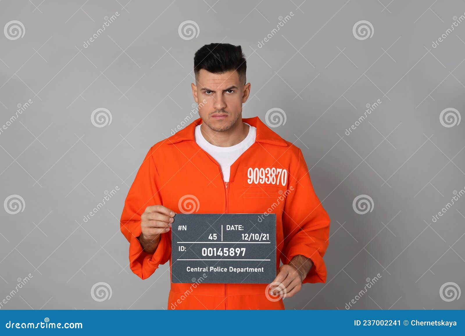 Mug Shot of Prisoner in Orange Jumpsuit with Board on Grey Background ... Mug Shot of Prisoner in Orange Jumpsuit with Board on Grey Background ...