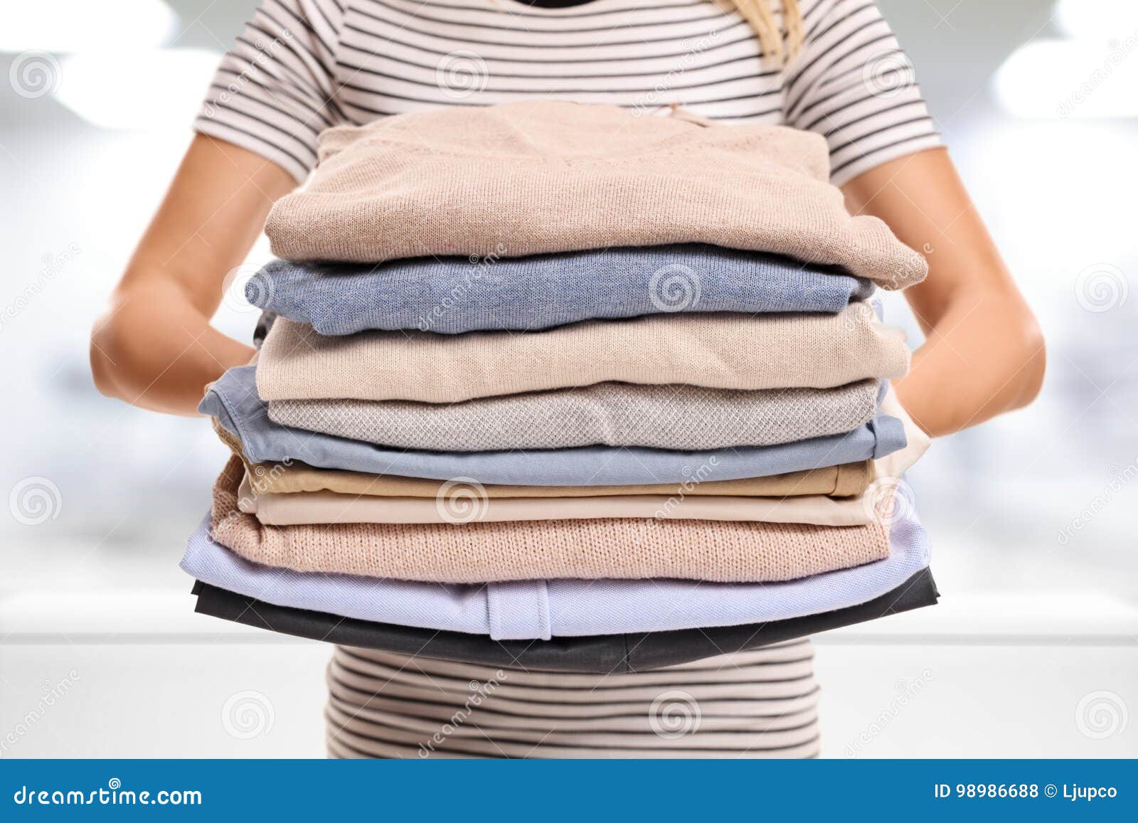 Mujer Con La Pila De Ropa Planchada Y Llena Foto de archivo - Imagen de ...