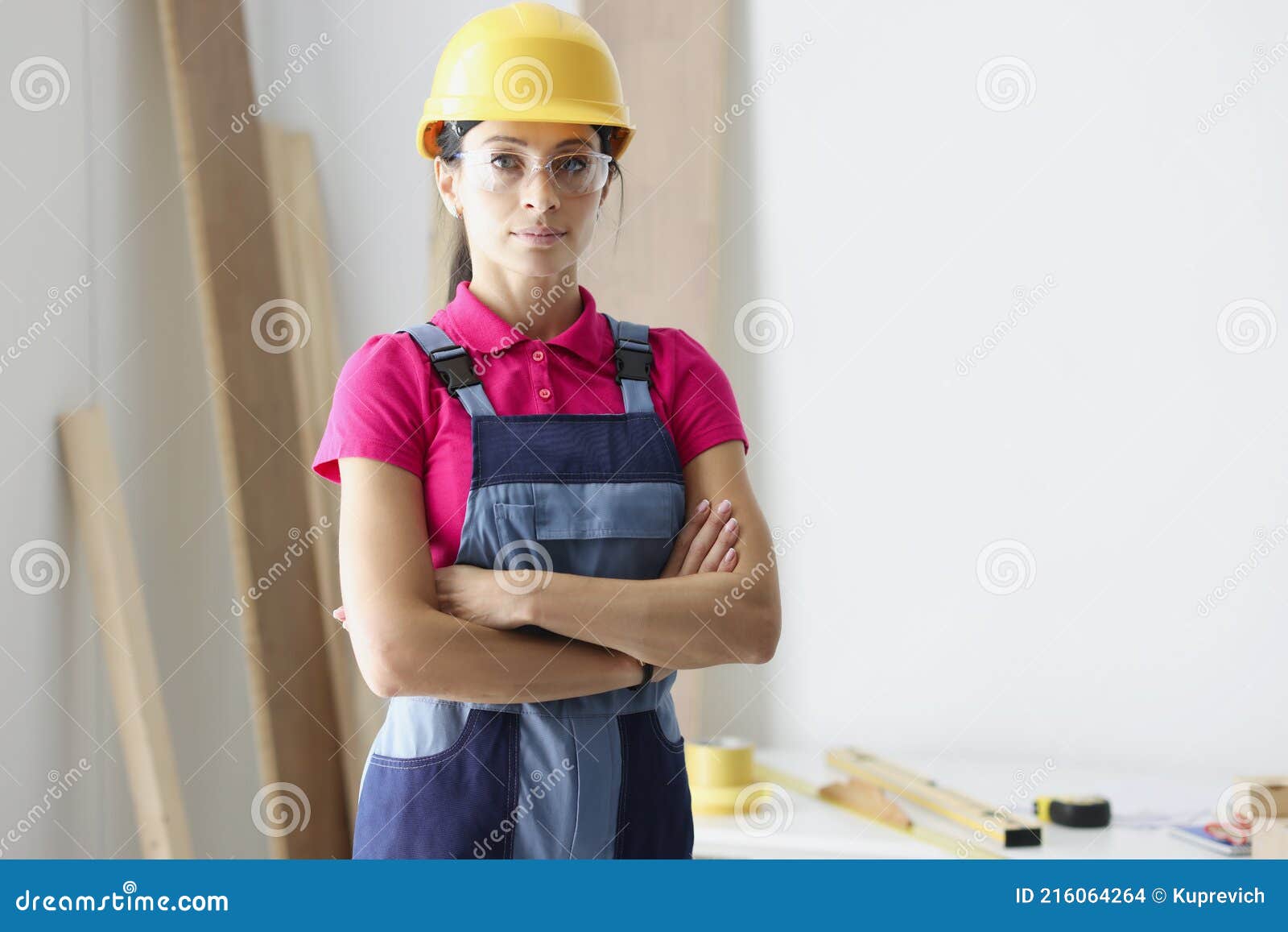 Mujer Constructora En Casco Protector De Pie En Taller Foto de archivo ...