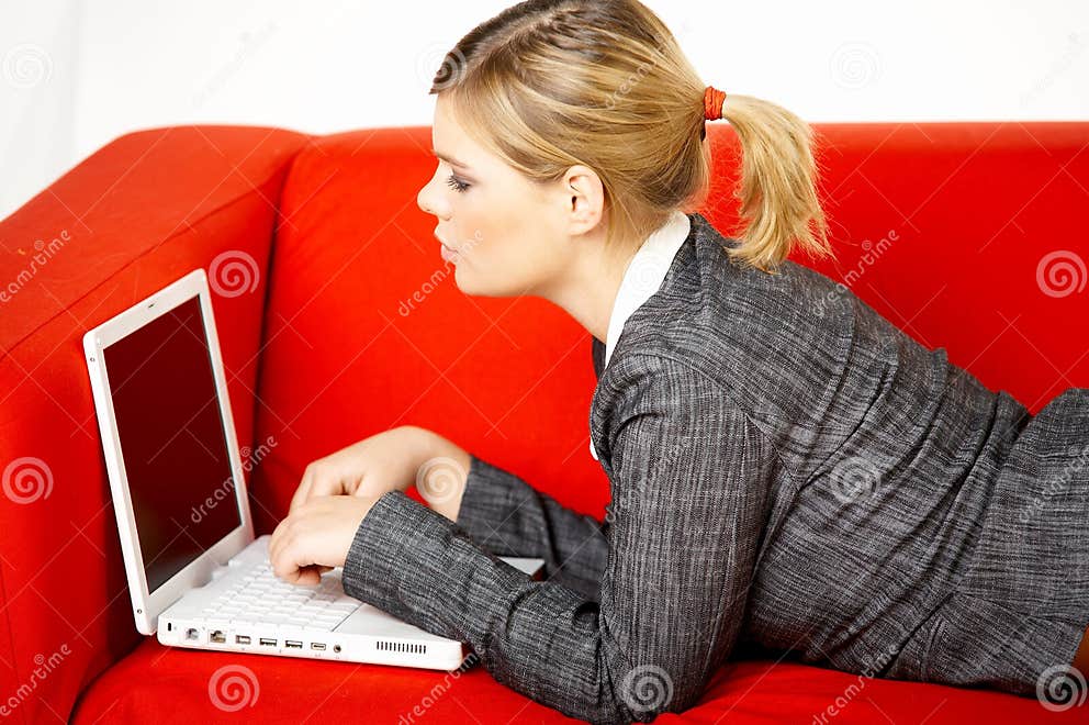 Mujer en el sofá rojo foto de archivo. Imagen de broadband - 1430026