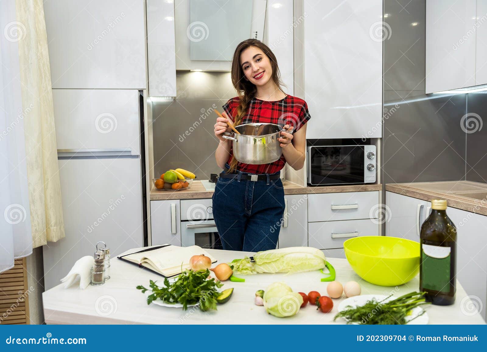 Mujer Joven Cocinando Comida En Una Olla En La Cocina Foto de archivo ...