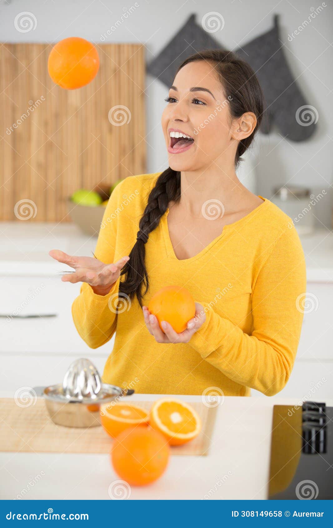 Mujer Joven Feliz Trotando Con Naranjas En La Cocina Foto de archivo ... Mujer Joven Feliz Trotando Con Naranjas En La Cocina Foto de archivo ...