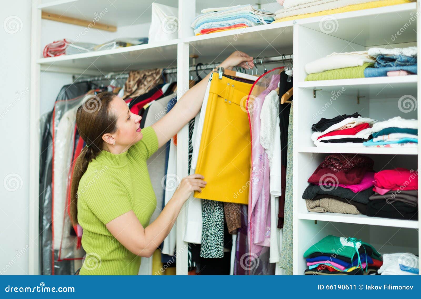 Mujer Que Arregla La Ropa En El Guardarropa Imagen de archivo - Imagen ...