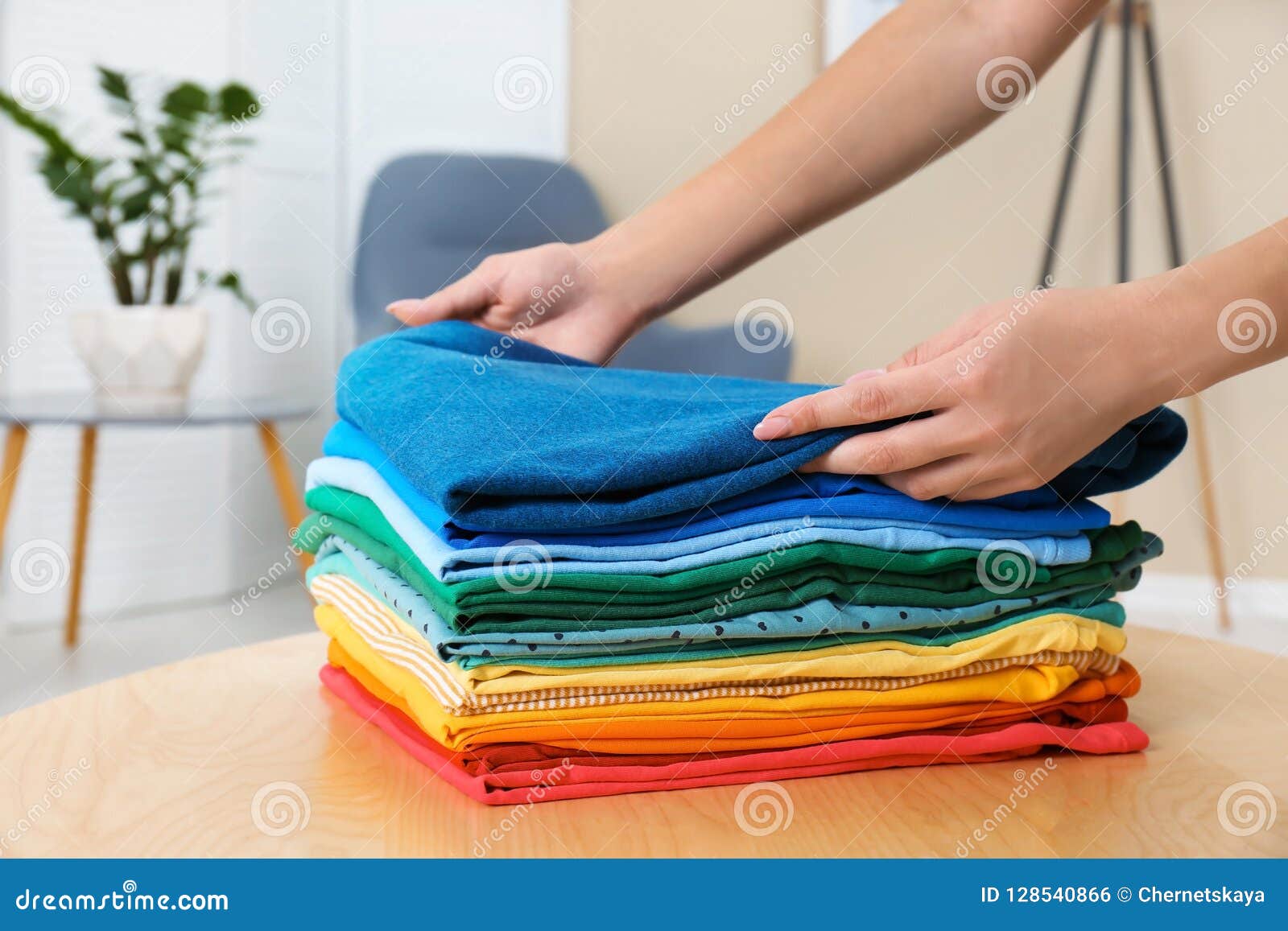 Mujer Que Dobla La Ropa Brillante En La Tabla Dentro Foto de archivo ... Mujer Que Dobla La Ropa Brillante En La Tabla Dentro Foto de archivo ...