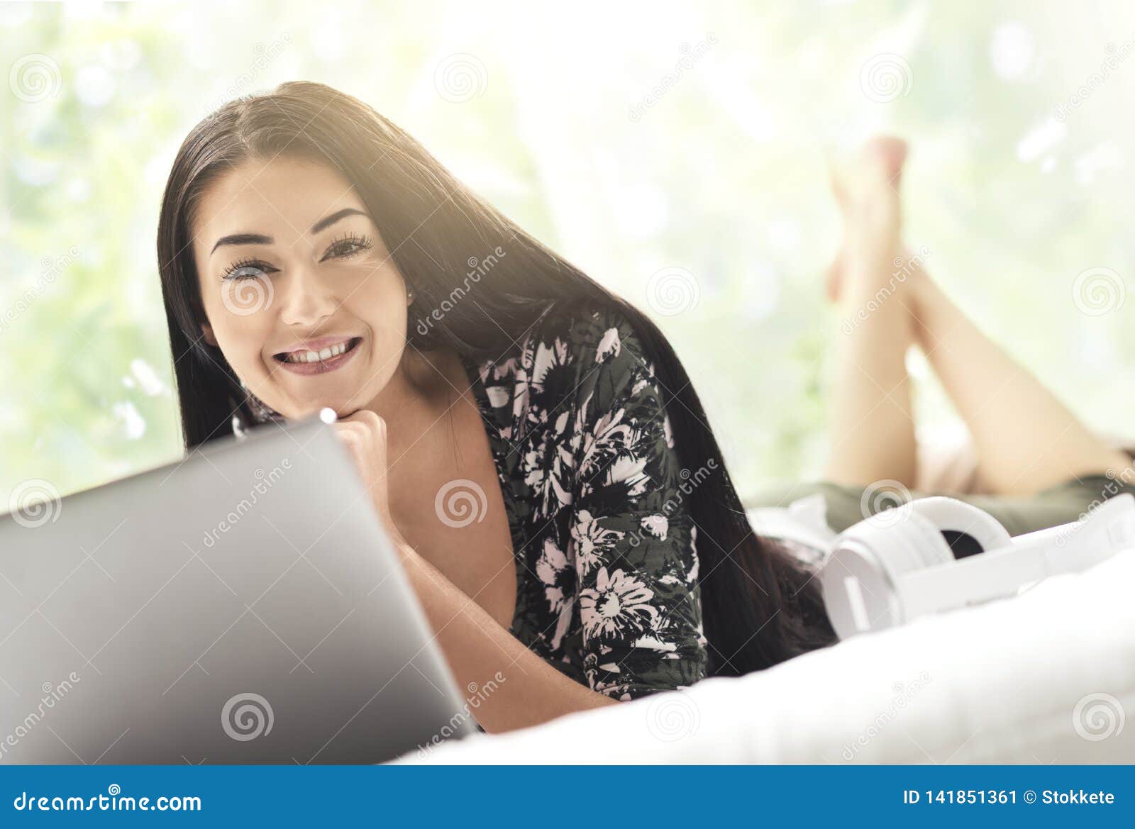 Mujer Que Miente En Cama Y Que Conecta Con Su Ordenador Portátil Imagen