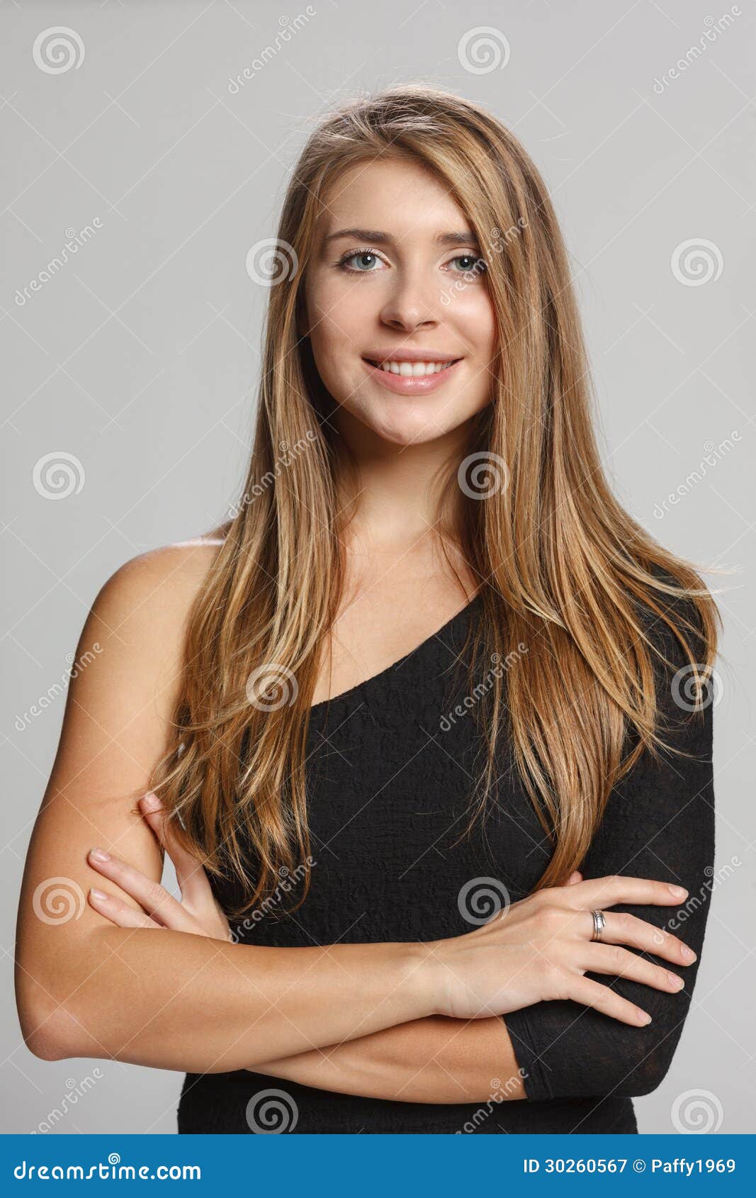 Mujer Sonriente Que Se Coloca Con Las Manos Dobladas Imagen De Archivo