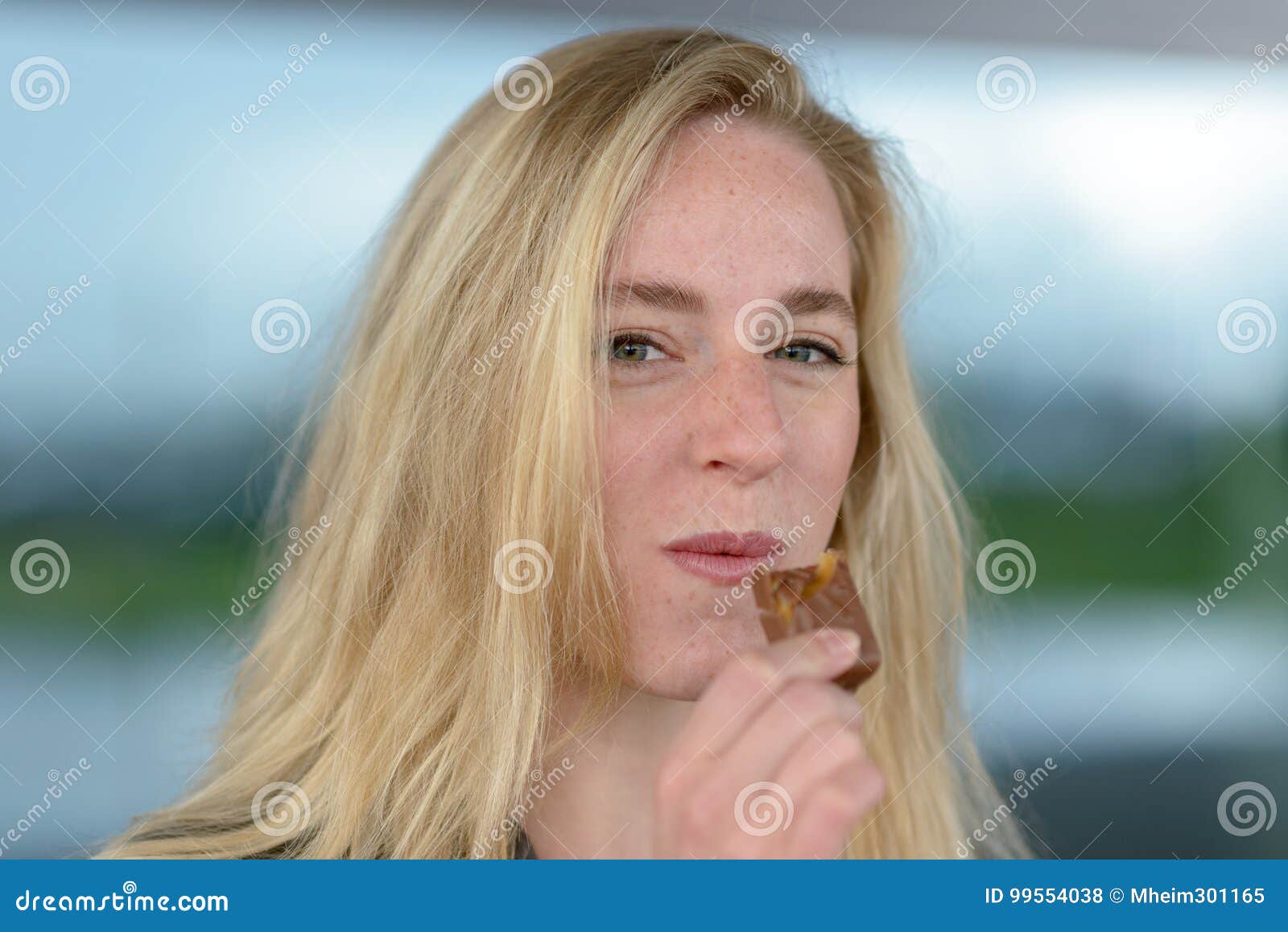 Mulher Loura De Sorriso Que Come O Chocolate Foto de Stock - Imagem de ...