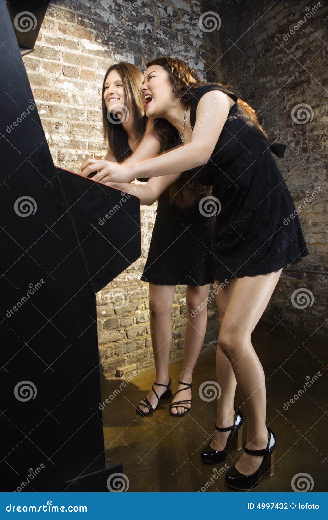 Mulheres Novas Que Jogam O Jogo Foto De Stock Imagem De Arcada Anos