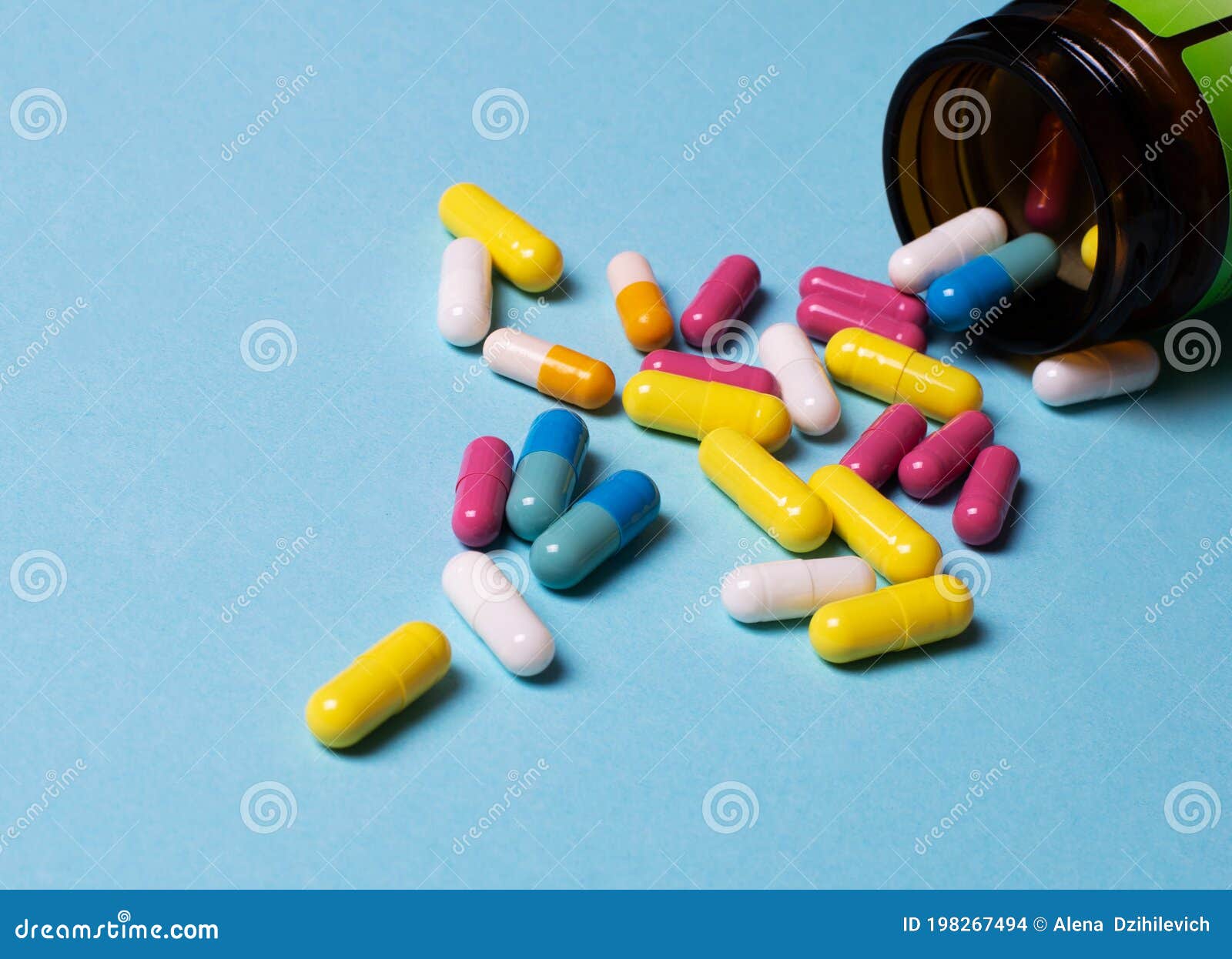 Multi-colored Capsules Scattered from a Bottle on a Blue Background ...
