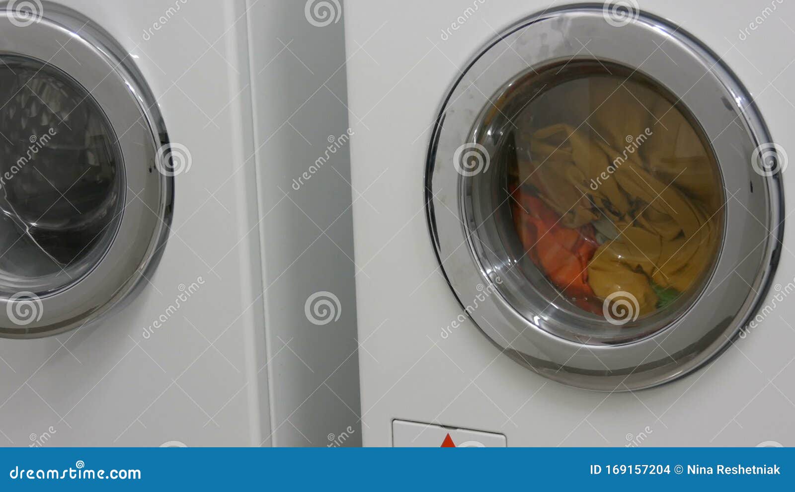Multi-colored Clothes Laundry is Washed in a White Washing Machine in ...