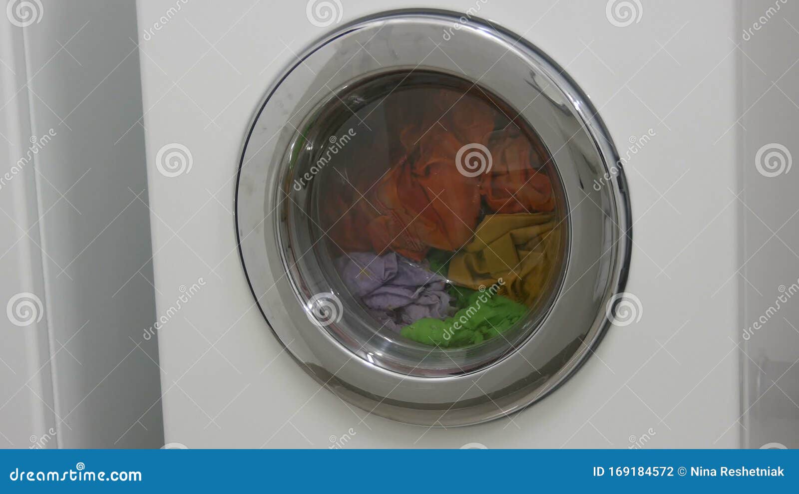 Multi-colored Clothes Laundry is Washed in a White Washing Machine in ...