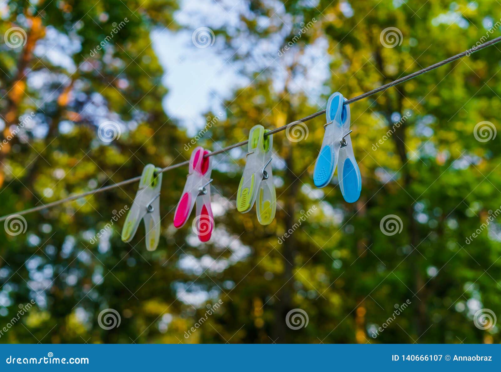 Multi-colored Four Clothes Pegs Attached To a Long Rope in the ...