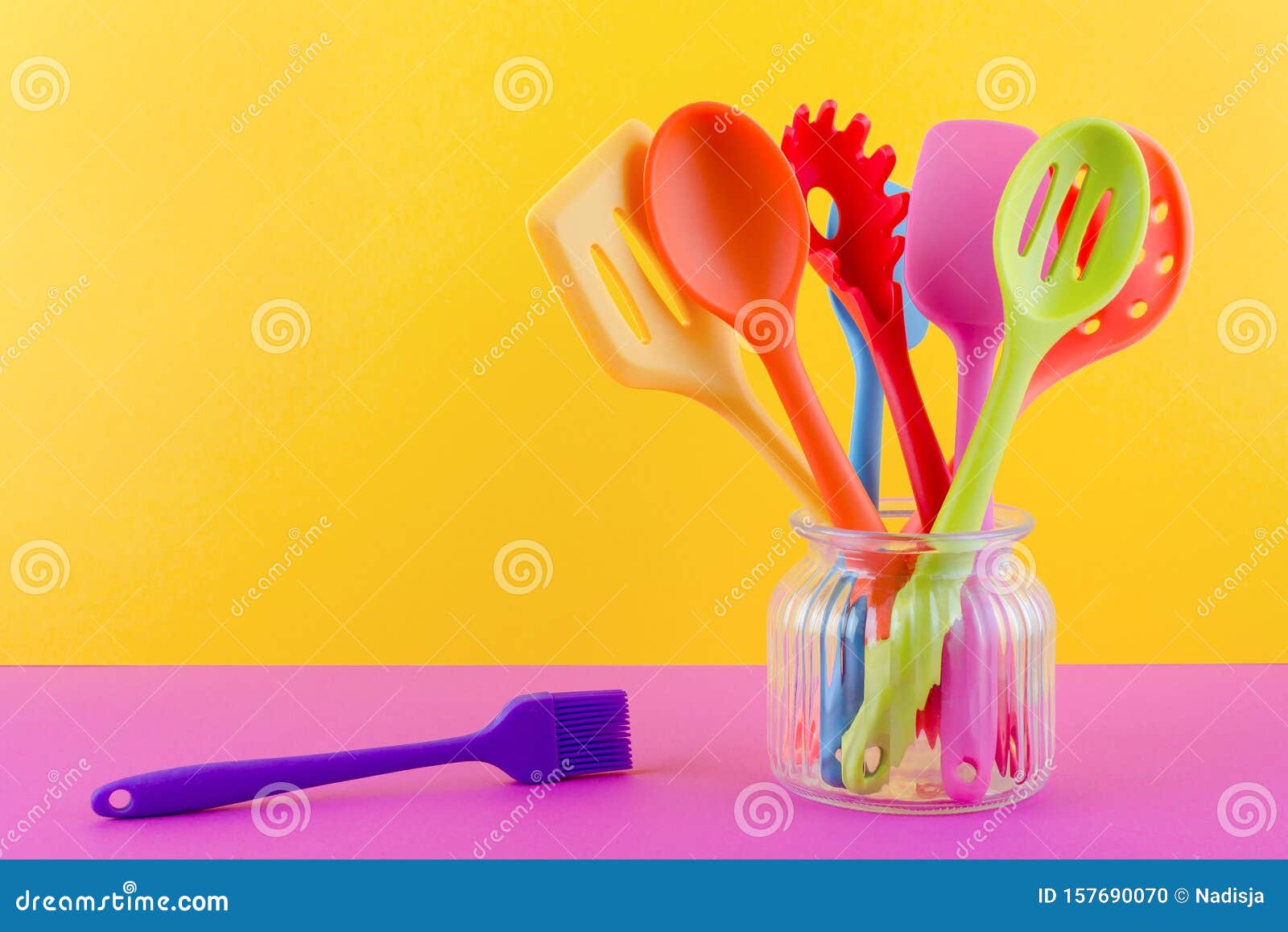 Bright Multi Colored Kitchen Utensils on Yellow Background with Copy ...