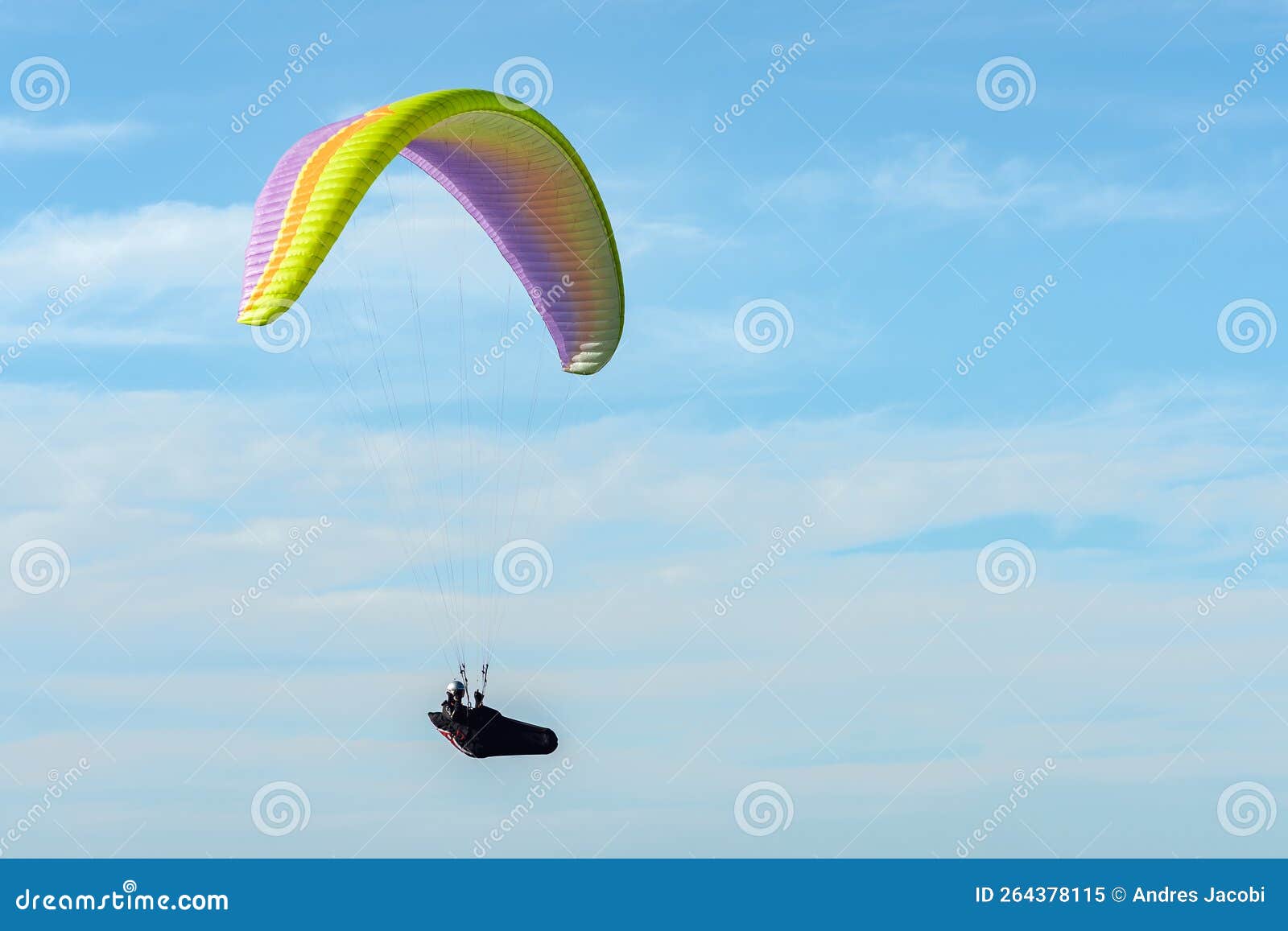 Multi Colored Paraglider Flying in the Sky on a Beautiful Blue Sky with ...