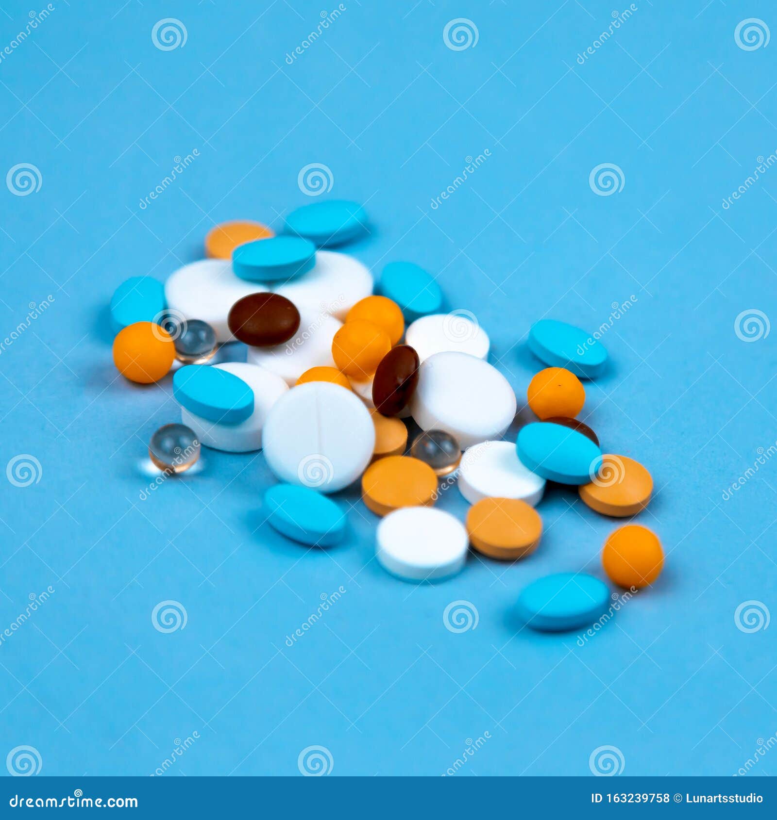 Multi-colored Pills on a Blue Background Close-up, with Copy Space for ...