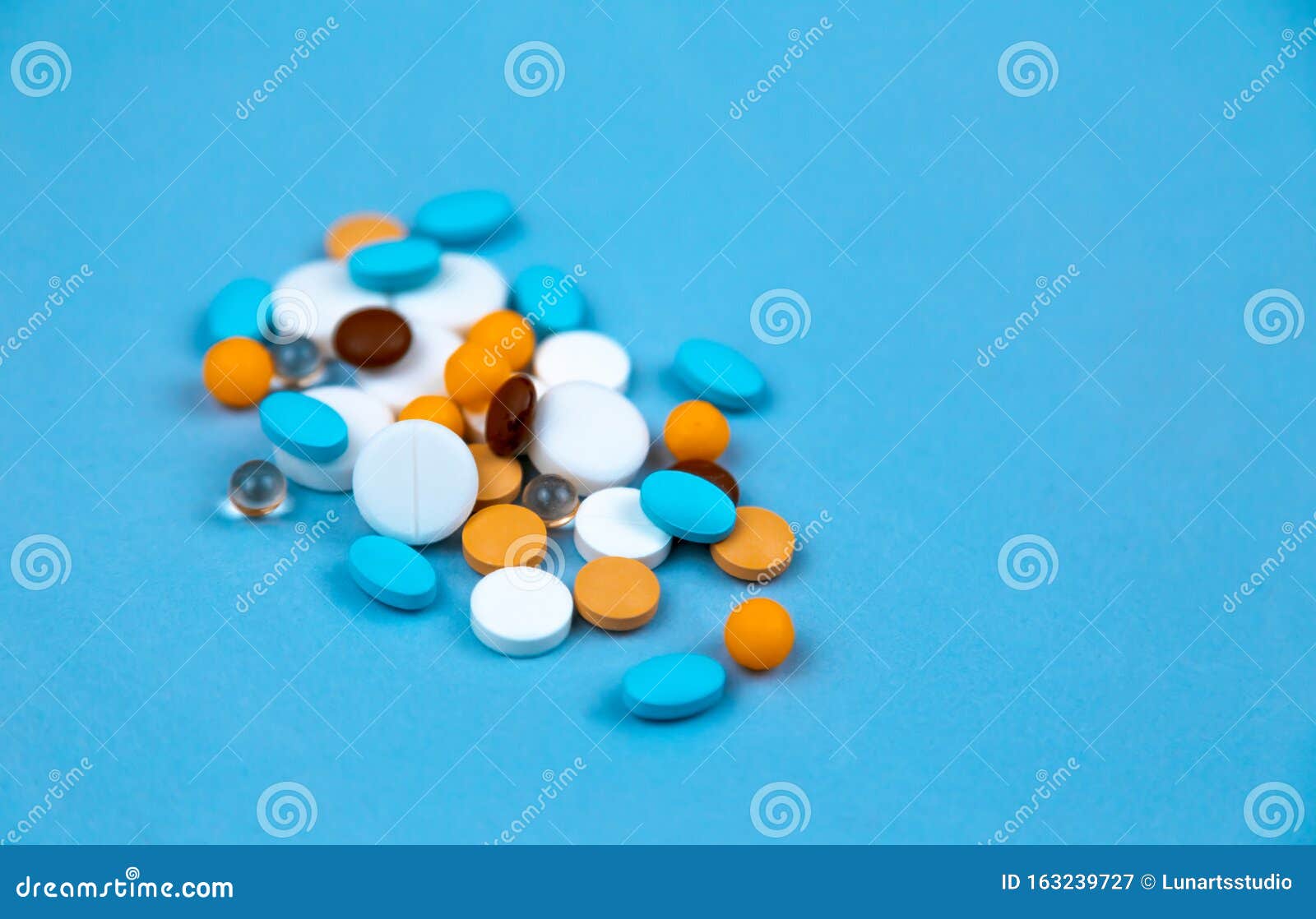 Multi-colored Pills on a Blue Background Close-up, with Copy Space for ...