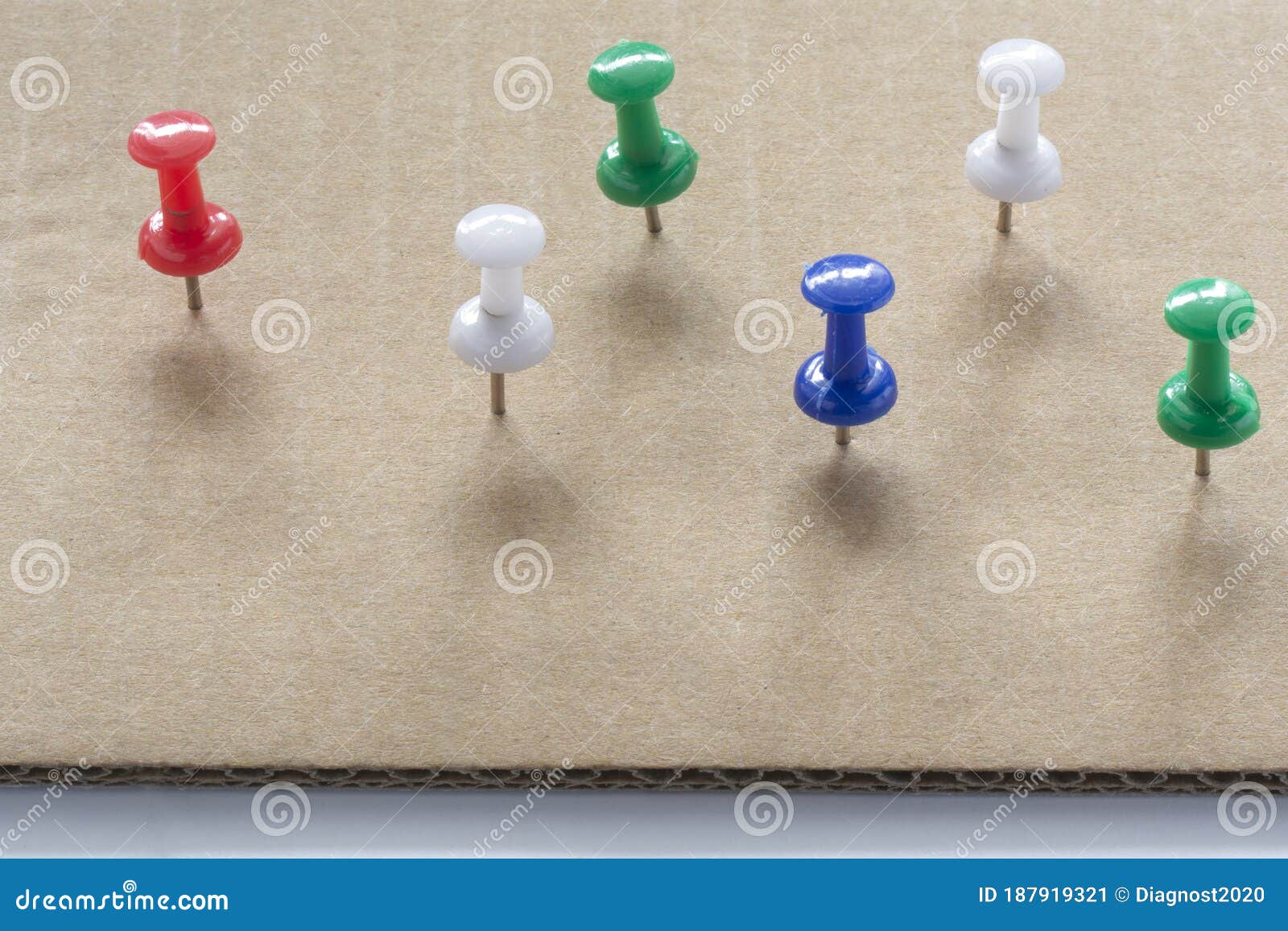 Multi Colored Push Pins on White Cardboard Paper Texture Background ...