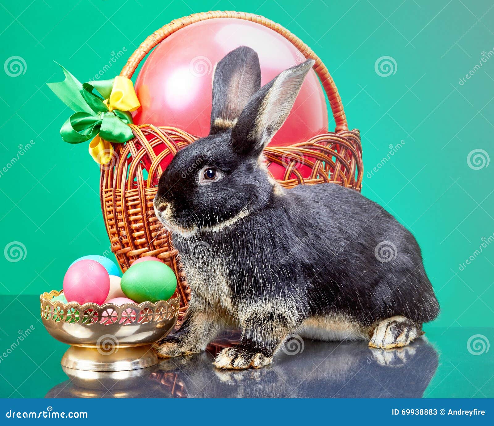 Multi-colored Rabbit Sitting Near Wicker Basket and a Vase with Easter ...