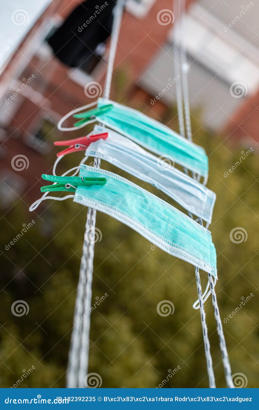 Multi-colored Surgical Masks Hanging on a Clothesline.Concept of Reuse ... Multi-colored Surgical Masks Hanging on a Clothesline.Concept of Reuse ...