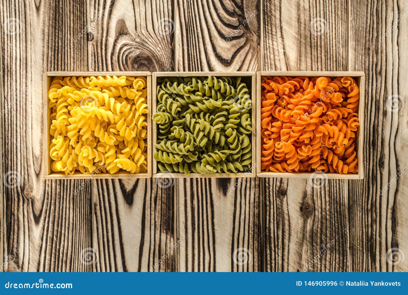 Multi-coloured Pasta in the Form of Spirals Lies in Square Wooden Boxes ...