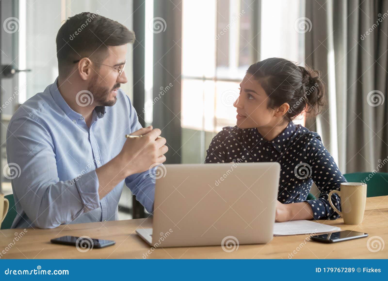Multi-ethnic Co-workers Discuss Project Sitting at Workplace Stock ...
