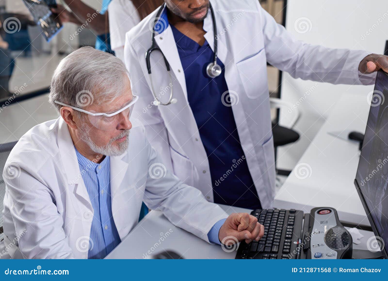 Multi-ethnic Group of Radiologists Discussing Diagnosis Using Monitors ...