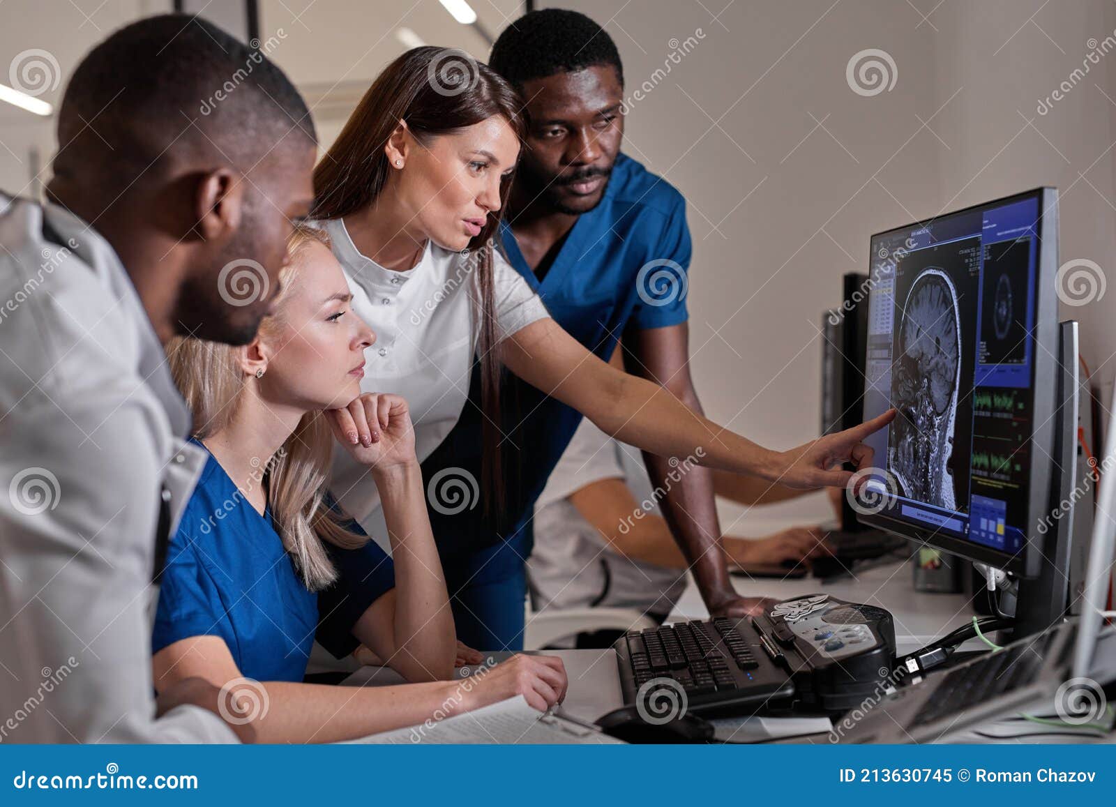 Multi-ethnic Group of Radiologists Discussing Diagnosis Using Monitors ...