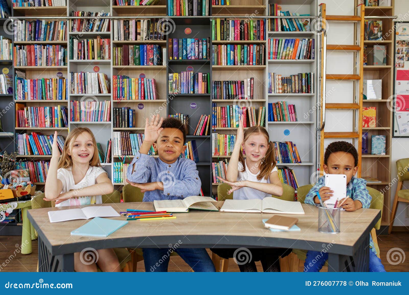 Multi-ethnic Pupils Study and Write at Table in Library or Classroom ...