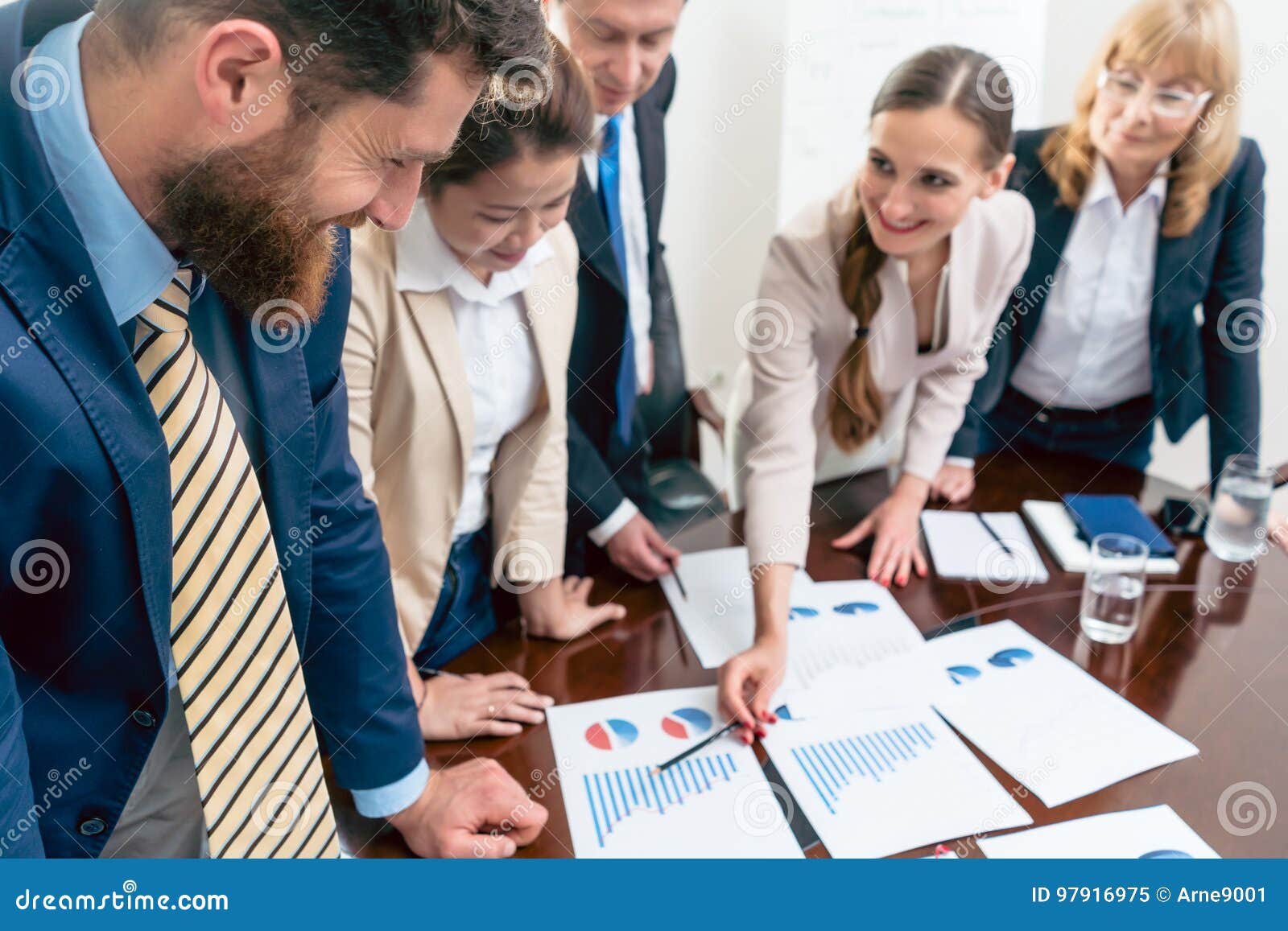 Multi-ethnic Team of Dedicated Specialists Smiling Anaylizing Business ...