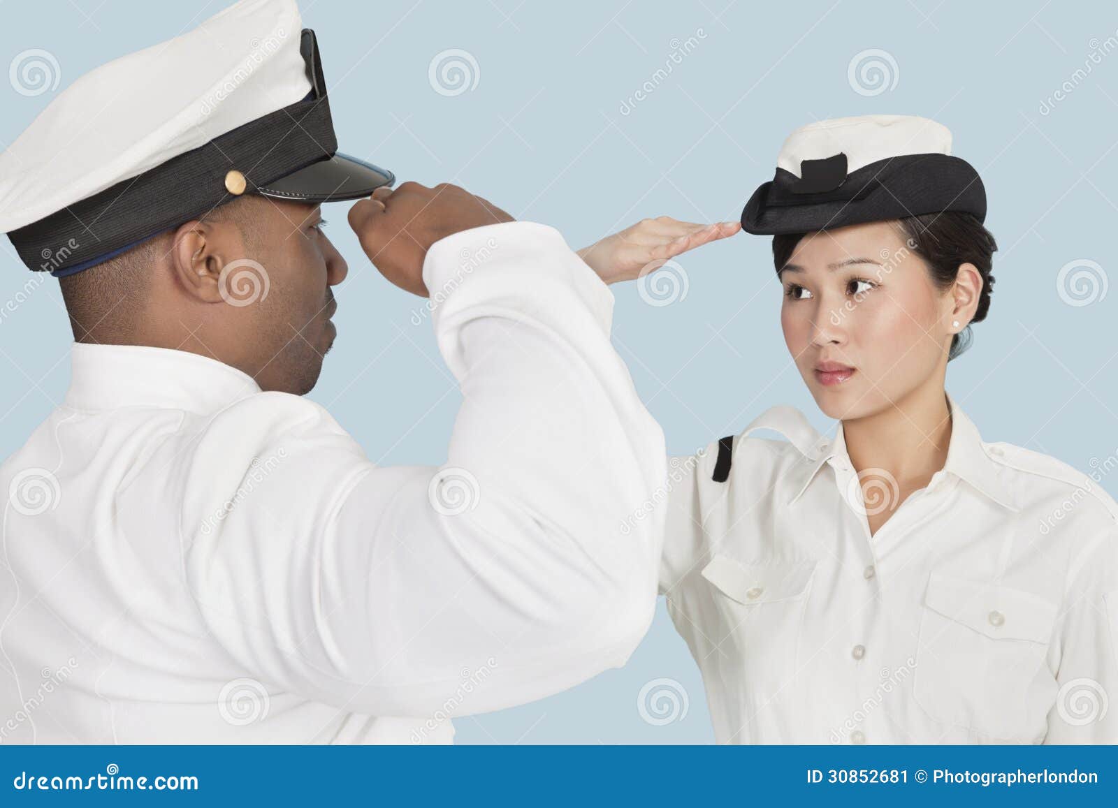 Multi-ethnic US Navy Officers Saluting Each Other Over Light Blue ...