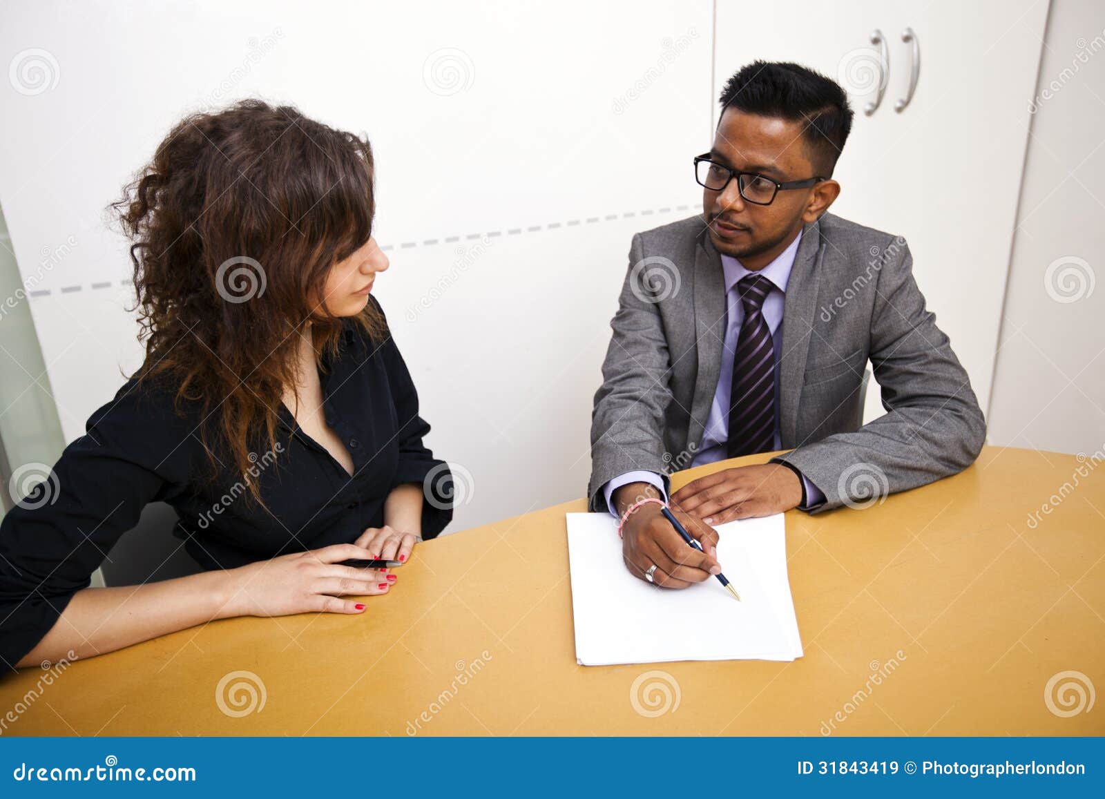 Multi-ethnic Work Colleagues Signing Paperwork on a Table Stock Image ...