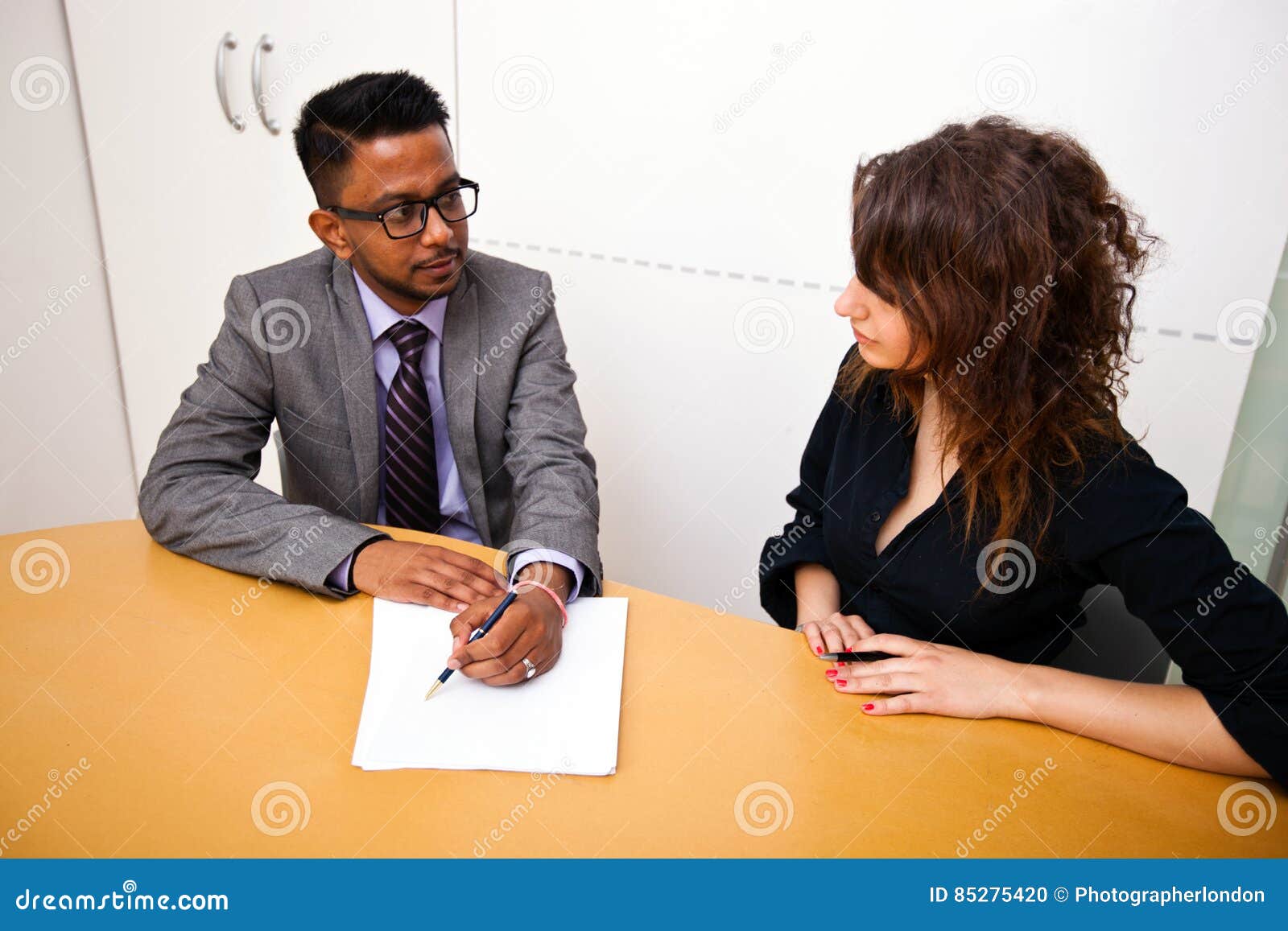 Multi-ethnic Work Colleagues Signing Paperwork on a Table Stock Photo ...