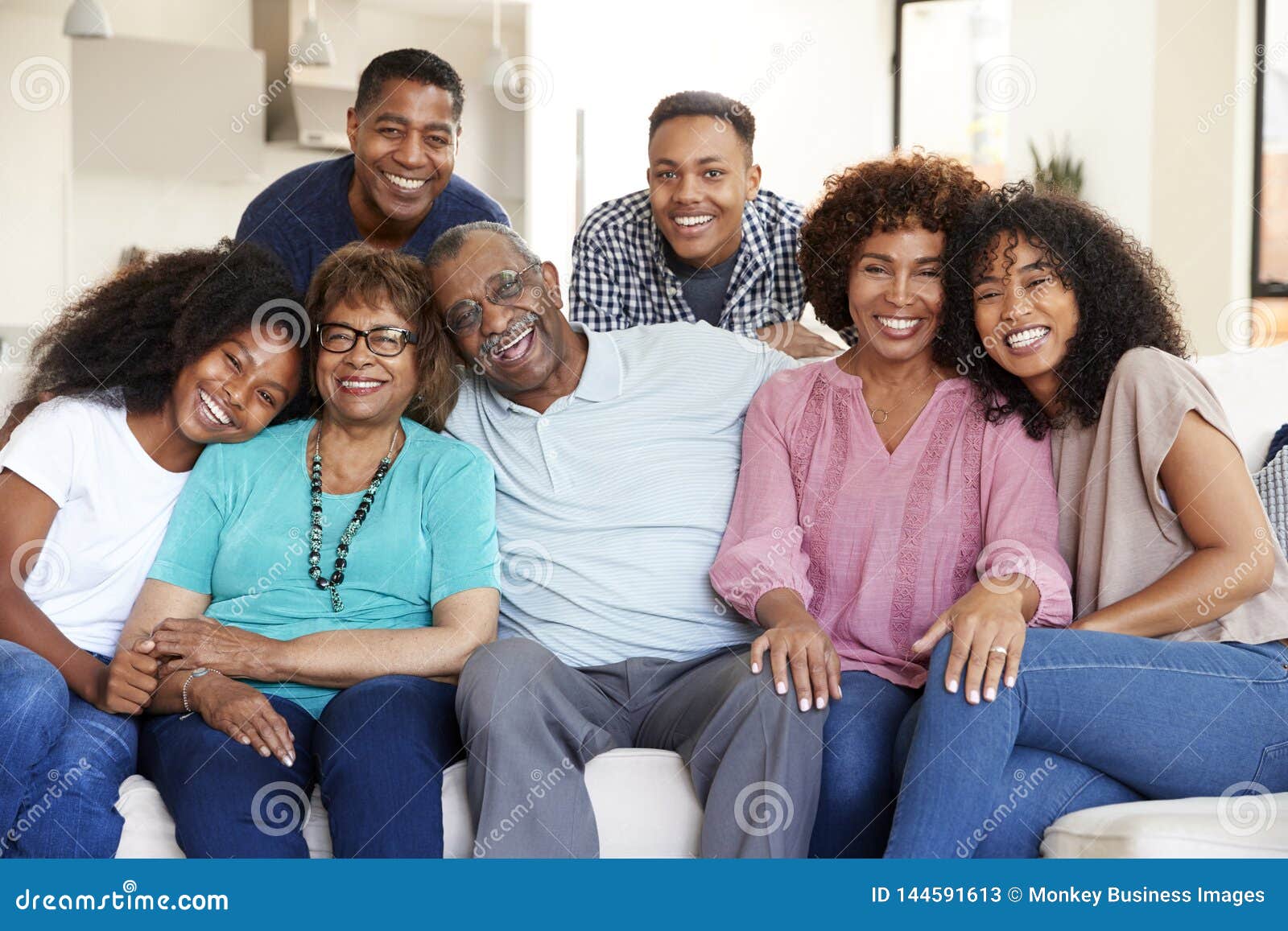 Multi Generation African American Family Sitting at Home Smiling To ...