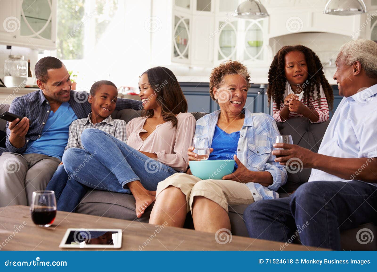 Multi Generation Black Family Talking Together While Watching TV ...