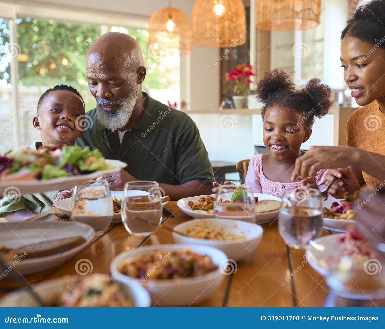 Multi-Generation Family Around Table Serving and Eating Meal at Home ...