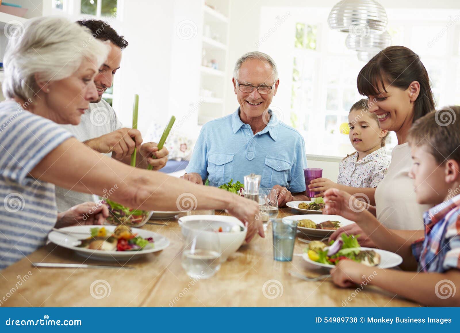Multi Generation Family Eating Meal Around Kitchen Table Stock Photo ...