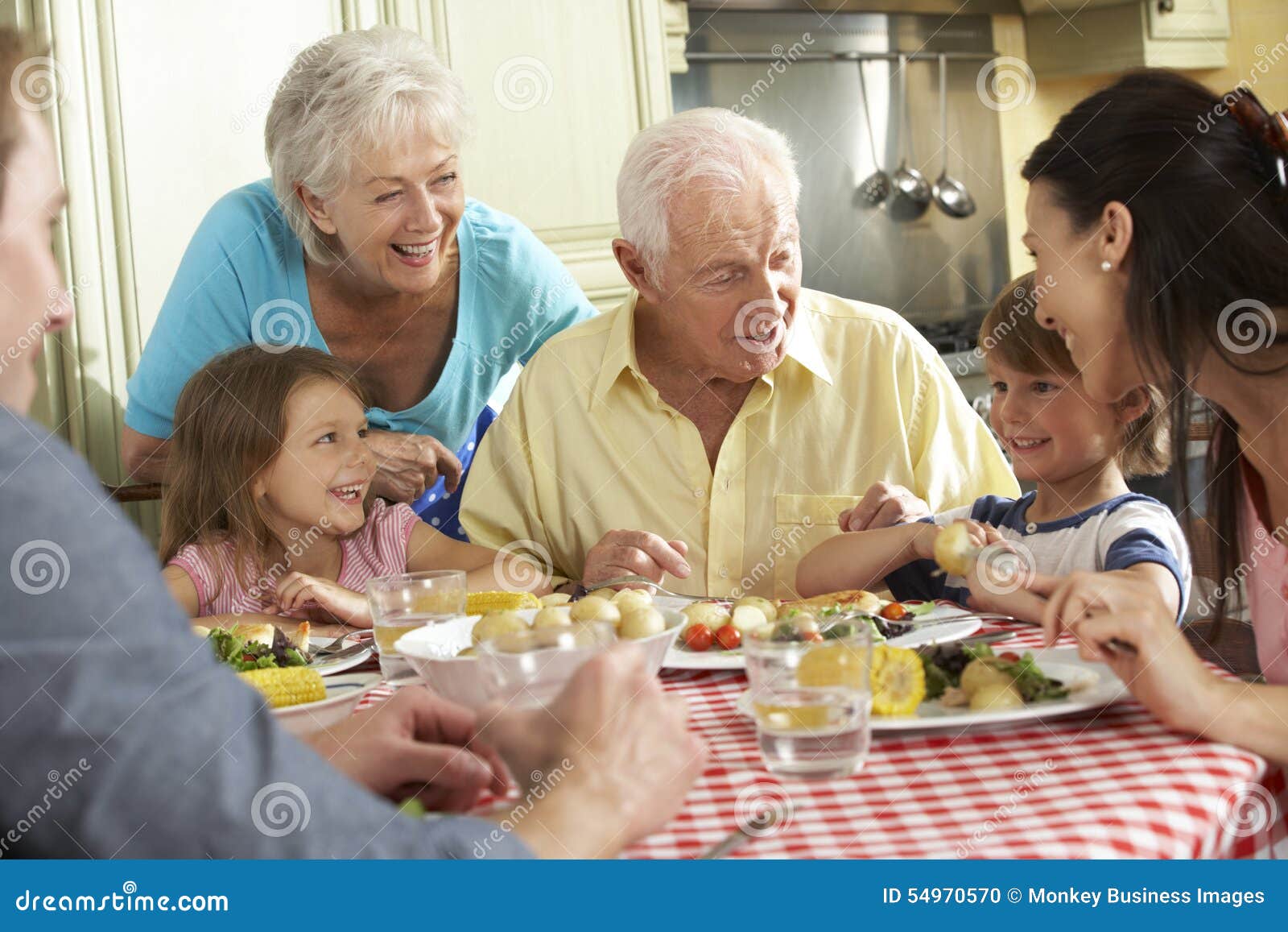 Multi Generation Family Eating Meal Together in Kitchen Stock Photo ...