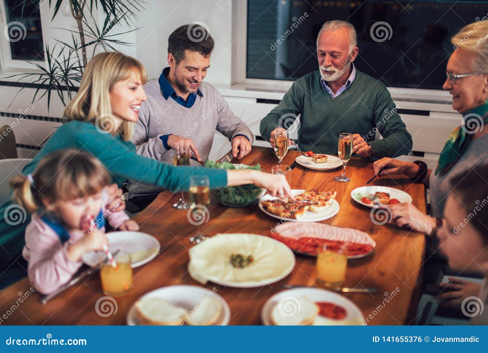 Multi Generation Family Enjoying Meal Around Table Stock Photo - Image ...