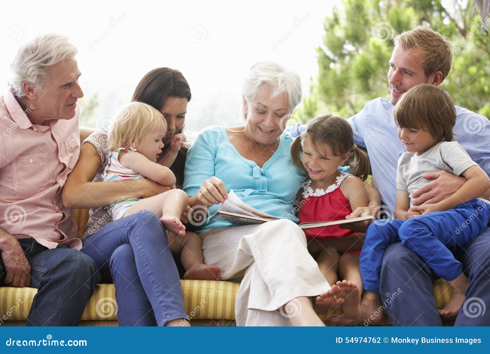 Multi Generation Family Reading Book on Garden Seat Stock Photo - Image ...
