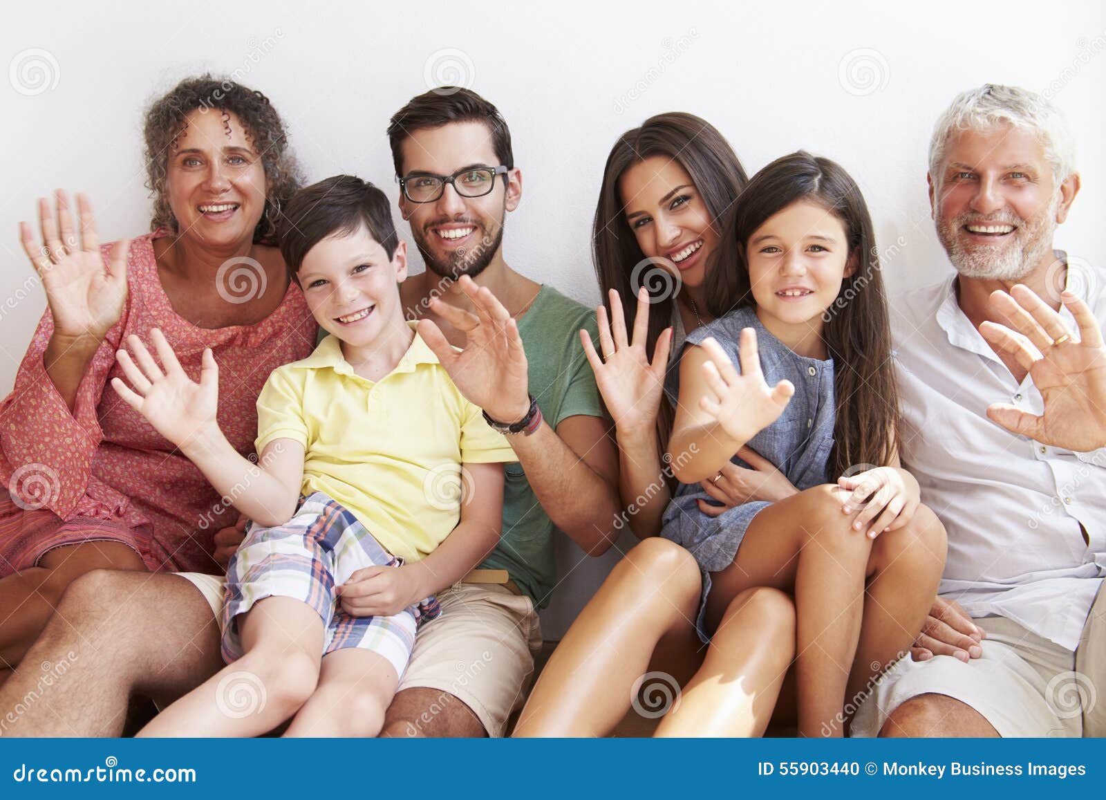 Multi Generation Family Sitting Against Wall and Waving Stock Photo ...