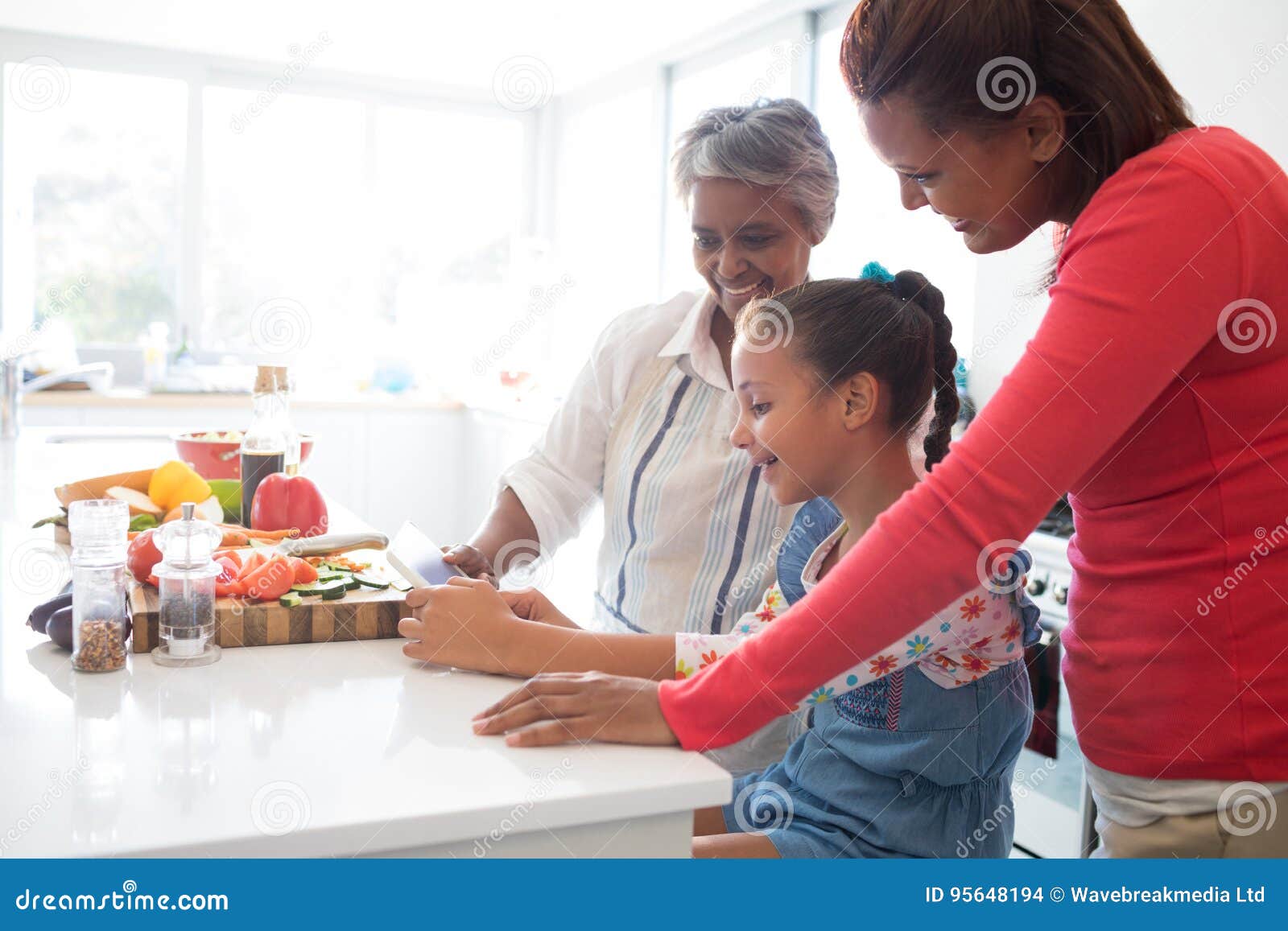 Multi-generation Family Using Digital Tablet in the Kitchen Stock Photo ...