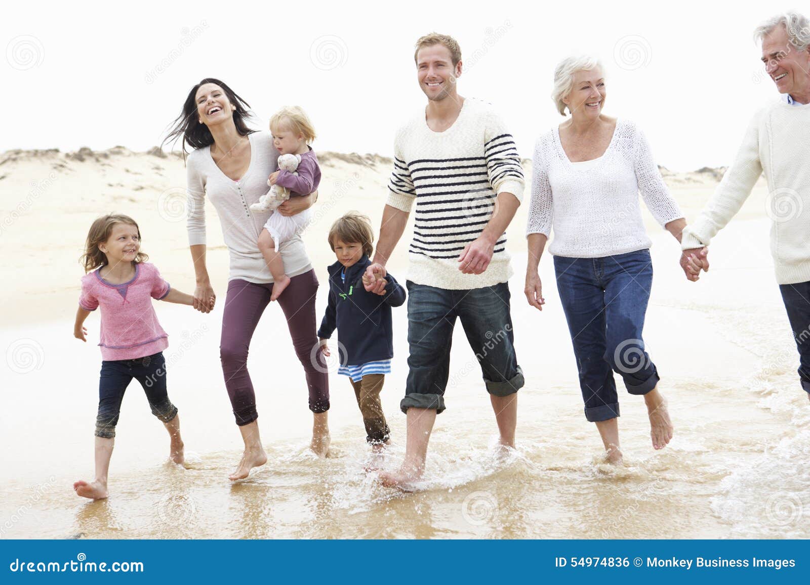 Multi Generation Family Walking Along Beach Together Stock Photo ...